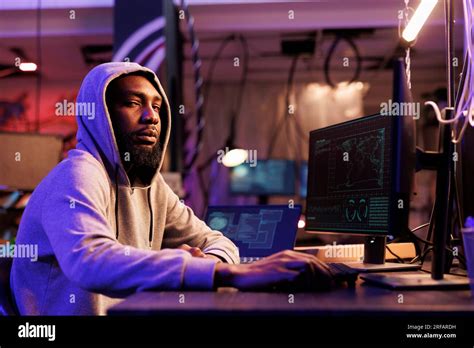 Hacker In Hood Hacking Computer System And Looking At Camera Young