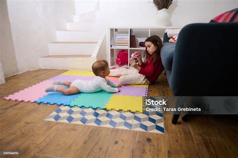 귀여운 어린 소녀의 측면 초상화 아늑한 집 인테리어의 다채로운 퍼즐 카펫에서 아기 소년 남동생과 놀고 있는 사랑스러운 돌보는 여동생 아이 행복한 가정과 세계 어린이날 컨셉