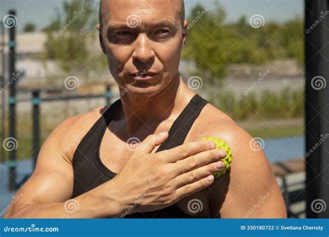 Athletes Man Is Massaging His Shoulder By Massage Ball Techniques For Tense After Active Workout