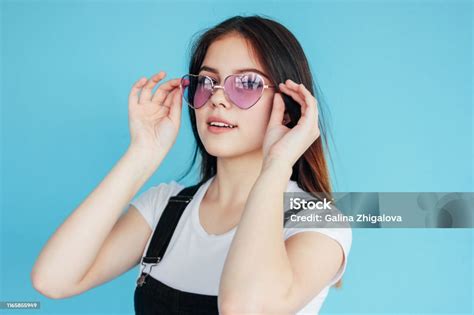 파란색 배경에 고립 된 흰색 티셔츠에 어두운 긴 머리와 심장 모양 선글라스에 아름다운 소녀 T 셔츠에 대한 스톡 사진 및 기타 이미지 T 셔츠 관능 교육 Istock