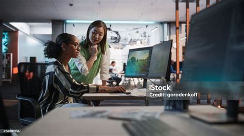 3d 모델링 소프트웨어가 설치된 데스크톱 컴퓨터를 사용하는 흑인 여성 게임 디자이너와 게임 개발 스튜디오 사무실에서 아시아 여성