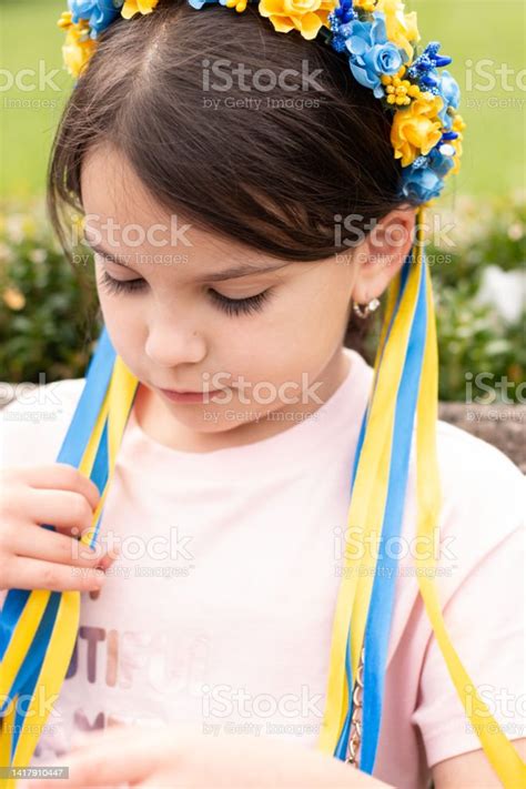 그녀의 머리에 우크라이나 민속 장식과 슬픈 소녀 야외에 서있는 동안 화환 리본을 만지는 어린 아이 6 7 살에 대한 스톡 사진 및 기타 이미지 Istock