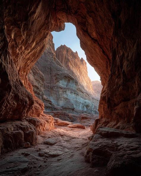 Open Cave In Towering Desert Cliff Face Showing Layers Of Red Rock And