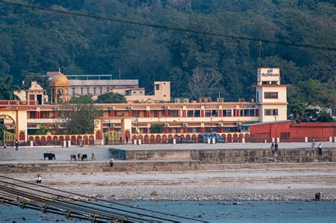 리시케시 건너편에 있는 아쉬람에는 주전자와 남자들이 걸어가는 모습 그리고 근처에 앉아 있는 사람들이 있습니다 환경은 평화롭고 매력적입니다 갠지스 강에 대한 스톡 사진 및