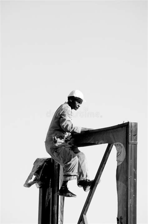 Construction Worker Climbing Steel Framework On A Sunny Day Showcasing