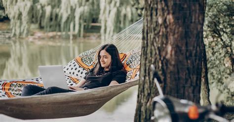 호수 근처의 해먹에 누워 노트북으로 작업하는 젊은 여성 프리랜서 복고풍 이탈리아 오토바이 근처에서 자연에서 쉬고 있는 힙스터 여성 사진 Unsplash의 우크라이나 이미지