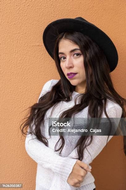 긴 물결 모양의 머리카락을 가진 젊은 여성 모델 모자를 착용하고 웃는 액세서리 라틴 여성 패션과 아름다움 개인 장식품에 대한 스톡 사진 및 기타 이미지 Istock