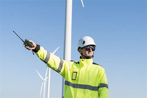 풍력 터빈 농장에서 무전기로 안전 유니폼과 헬멧 작업 및 제어 풍력 터빈을 착용하는 남성 엔지니어 풍차 현장 농장에서 풍력 터빈 유지 보수를 계획하는 남성 기술자 30 34