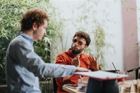 Young Architects Review Blueprints Plan Details And Project Costs During A Site Inspection