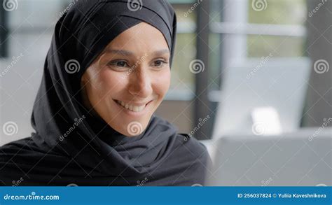 Cute Positive Arab Woman In Hijab Looks At Laptop Screen Smiling Watching Funny Video On