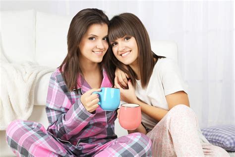 Premium Photo Beautiful Girls Twins In Pajamas Drinking Tea At Home