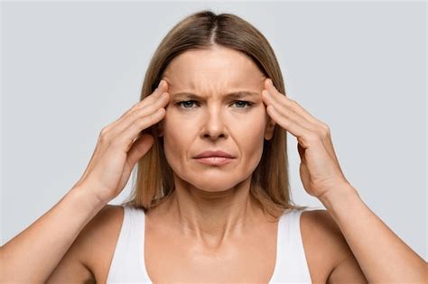 Premium Photo Irritated Blonde Middle Aged Woman Rubbing Her Temples