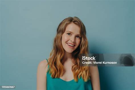 파란 스튜디오 배경에서 고립된 포즈를 취하고 부드러운 미소로 카메라를 바라보는 행복한 젊은 여성 30 34세에 대한 스톡 사진 및 기타 이미지 Istock