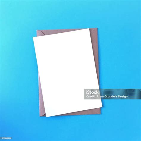갈색 공예 종이 봉투와 파란색 배경에 빈 흰색 엽서 엽서 문구 류 제품 인사말 카드 초대장 전단지 전단지 문구 플랫 레이의 모형 업에 적합합니다 0명에 대한 스톡 사진 및