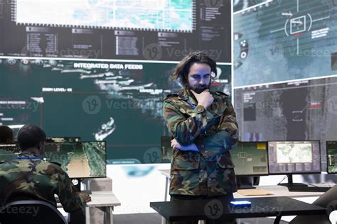 Military Staff Examining Global Satellite Surveillance Footage On A Hologram Monitoring Troops