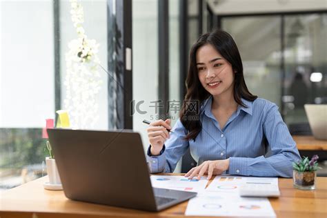 女商人使用计算器在办公室木桌上进行数学财务和商业工作背景、税务、会计、统计和分析研究概念高清摄影大图 千库网