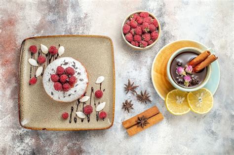 Свежеиспеченный торт с малиной чашка черного чая с лимоном и корицей ...