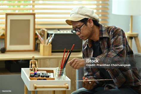 편안한 아트 스튜디오에서 캔버스에 그림을 그리는 젊은 재능있는 남성 예술가의 사진 그리기에 대한 스톡 사진 및 기타 이미지