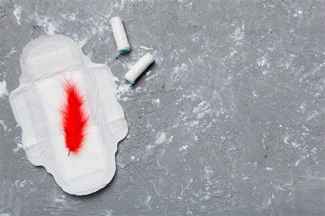 Женские прокладки и тампонные гигиенические прокладки лежат рядом с тампоном на изолированном