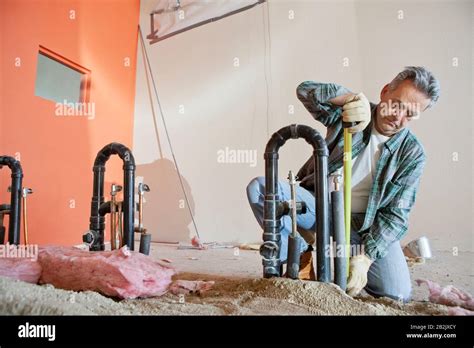 Mature Man Measuring Pipe With Tape At Construction Site Stock Photo Alamy