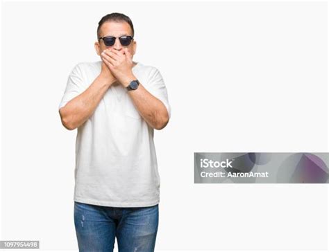 중세 아랍 남자 Wearig T셔츠와 선글라스 입 실수에 대 한 손으로 다루는 충격된 절연된 배경 위에 흰색 비밀 개념입니다 T 셔츠에 대한 스톡 사진 및 기타 이미지