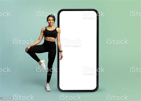 온라인 운동을위한 모바일 응용 프로그램 젊은 피트 니스 여자 서 근처 거대한 스마트폰 흰색 빈 화면 모형 스포츠에 대한 스톡 사진 및 기타 이미지 Istock