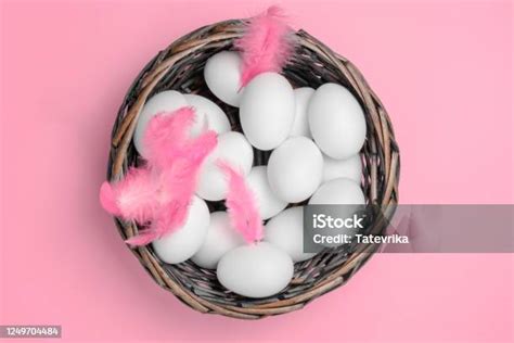 질감이 있는 종이 배경에 깃털이 달린 고리버들 바구니에 흰 달걀 부활절 기호 중 하나 0명에 대한 스톡 사진 및 기타 이미지 0명 갈색 개념 Istock