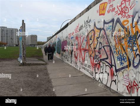 Visitors Walk Along A Still Standing Section Of The Former Berlin Wall