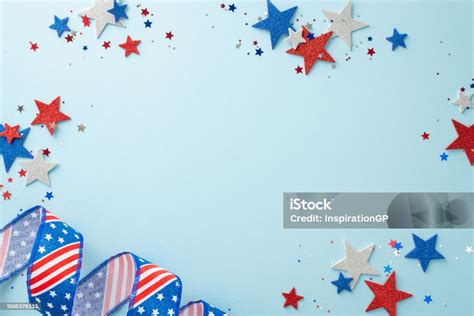 애국적인 축하를 위한 축제 요소 곱슬곱슬한 리본 반짝이는 별 색종이 조각 파스텔 블루 배경에 텍스트 또는 광고를 위한 빈 원이 있는 평면도 배열a Top View