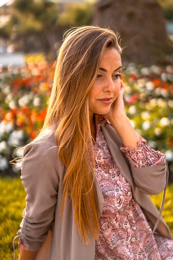 라이프 스타일 젊은 기업가 도시에서 적갈색 비옷과 꽃 드레스와 백인과 금발 아름다운 공원에서 꽃 옆에 공중 촬영 사려 깊은 젊은 여자 20 24세에 대한 스톡 사진 및 기타