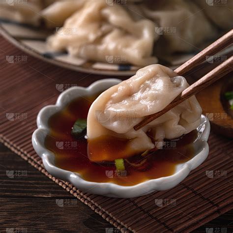 用筷子蘸着酱油吃新鲜水饺