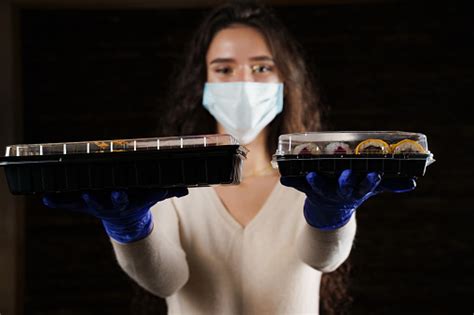 초밥 상자에 설정 된 건강한 음식 배달 서비스 2 개의 초밥 상자가있는 의료 용 마스크에 소녀 택배 일본 요리 롤 간장 와사비