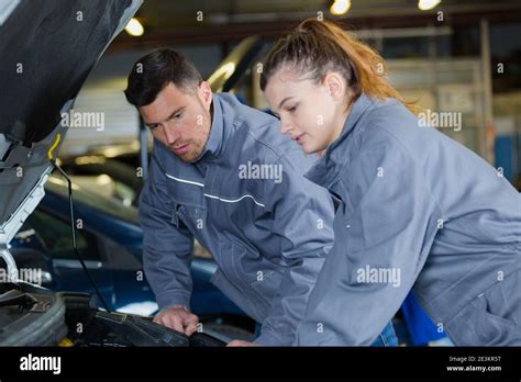 Mechanic Man And Woman Examine A Car Stock Photo Alamy