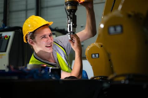 Premium Photo Technician Who Maintains A Small Robot Arm The Operation Of A Small Robot Arm