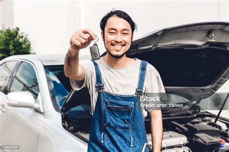 자동차 키를 잡고 자동차 엔진을 고정 하 고 자동차 서비스의 차량 후드 아래에서 검사를 수리 하는 유니폼 전문 자동차 정비사 교통수단에 대한 스톡 사진 및 기타 이미지