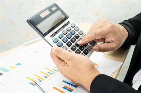 현대 사무실 재무 및 비즈니스 개념에서 차트 그래프 및 계산기로 재무 보고서 프로젝트 회계를 작업하고 분석하는 아시아 회계사