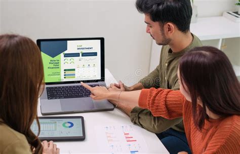 Asian Financial Advisor Presenting Charts And Data On A Tablet During Couple Client Meeting