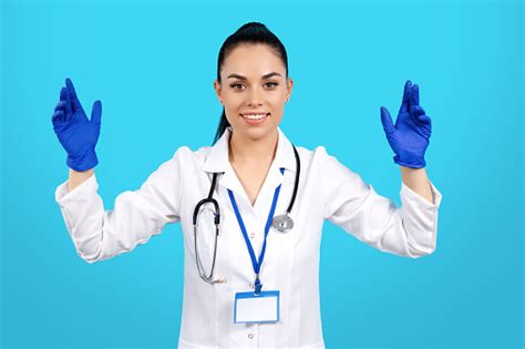 파란색 배경 위에 장갑을 착용 하는 청진 기를 가진 예쁜 젊은 여자 의사의 초상화 건강관리와 의술에 대한 스톡 사진 및 기타 이미지 건강관리와 의술 명랑한 몰도바