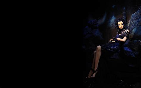 Красивая девушка в черном платье позирует в большом поле с розовыми цветами · бесплатная