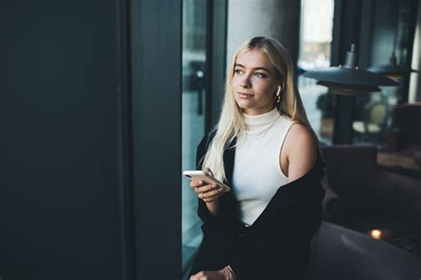 현대 레스토랑에서 무선 이어폰으로 휴대 전화로 말하는 사려 깊은 사업가 20 24세에 대한 스톡 사진 및 기타 이미지 20 24세 Mp3 플레이어 경영자 Istock