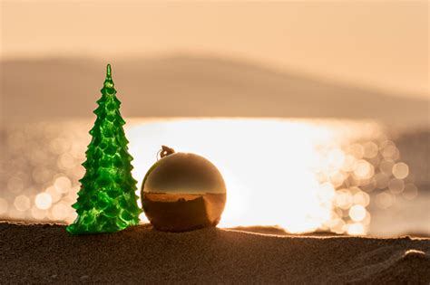 해변에서 크리스마스 트리와 황금 공과 배경에 보케와 흐릿한 바다 새해 복 많은 새해와 메리 크리스마스 인사말 카드 따뜻한 국가 개념의 겨울 휴일 복사 공간 0명에 대한 스톡