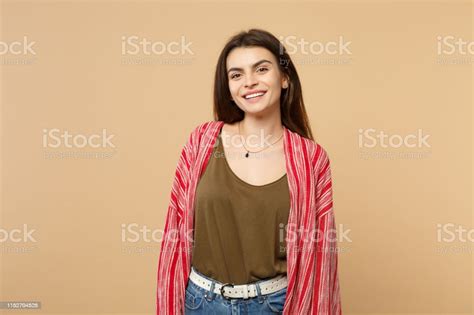 캐주얼 서 서와 스튜디오에서 파스텔 베이 지 벽 배경에 고립 된 찾고 카메라에 재미 웃는 젊은 여자의 초상화 사람들은 진심으로 감정 라이프 스타일 개념입니다 복사 공간을