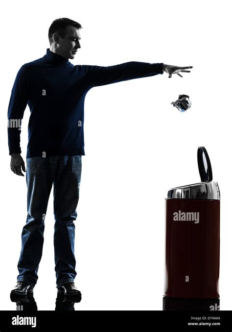 One Man Dropping A Paper In A Trash Bin Full Length In Silhouette Studio Isolated On White