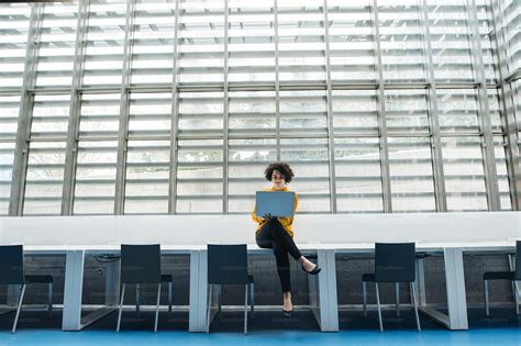 노트북을 사용하여 도서관이나 사무실의 방에서 책상에 앉아 있는 젊은 학생이나 사업가의 초상화 사진 Unsplash의 코워킹 이미지