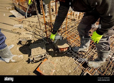 Worker Is Using Trowel To Fill Up Cube Mold Full With Concrete Sample