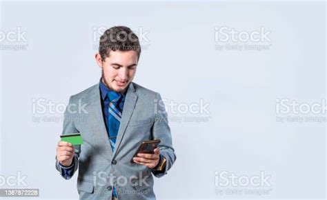 신용 카드와 휴대 전화를 손에 들고 있는 남자 고립 휴대 전화와 은행 카드 고립 된 은행 지불 개념으로 쾌활한 사업가 20 24세에 대한 스톡 사진 및 기타 이미지 Istock