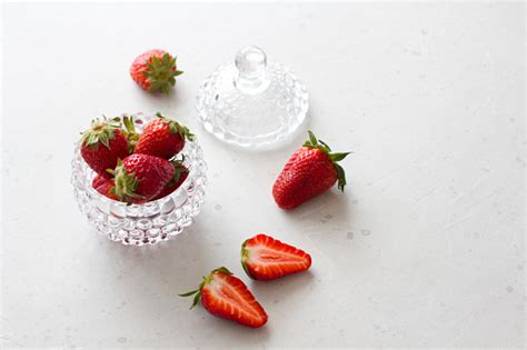 유리 둥근 그릇에 아름 다운 빨간 딸기 밝은 흰색 콘크리트 배경에 딸기 소박한 스타일 딸기 반을 잘라 수평 맨 위 보기 텍스트에