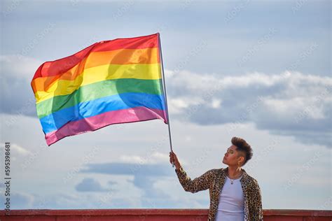 Gender Non Binary Asian Person Holding Rainbow Gay Pride Flag On Sky