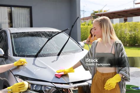 장갑과 극세사 세척 또는 광택 자동차를 가진 행복한 젊은 백인 가족 화창한 날 야외에서 함께 차를 청소하는 사랑스러운 가족의