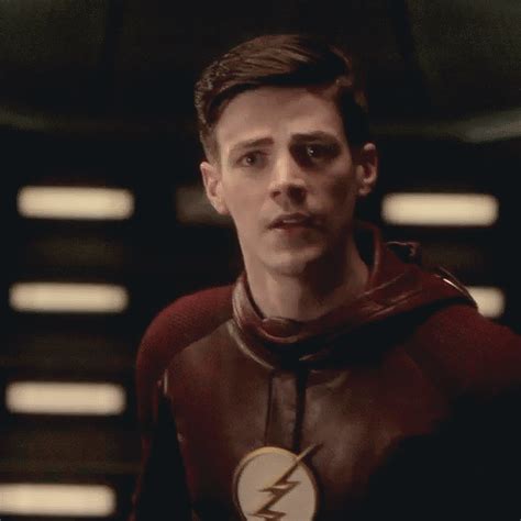 A Man In A Red And Black Costume With A Flash Symbol On His Chest Looking At The Camera